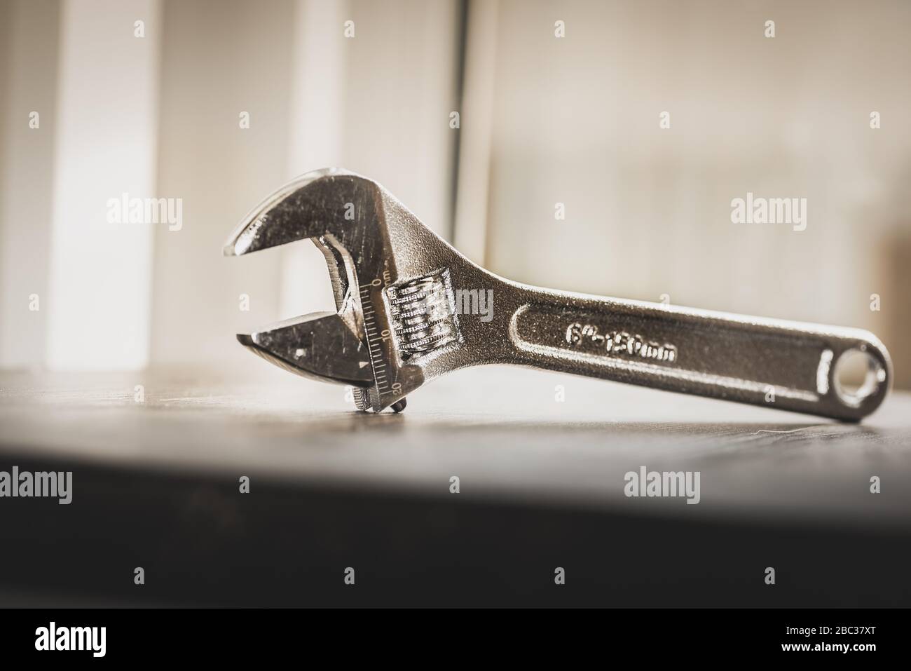 Wrench, French key, on a wooden table Stock Photo - Alamy