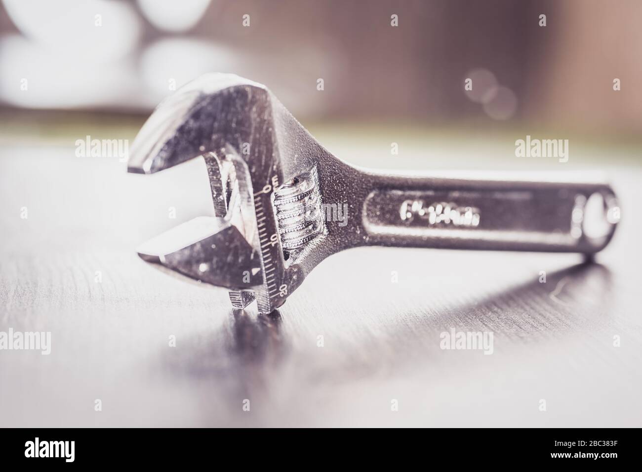 Wrench, French key, on blurred background Stock Photo - Alamy