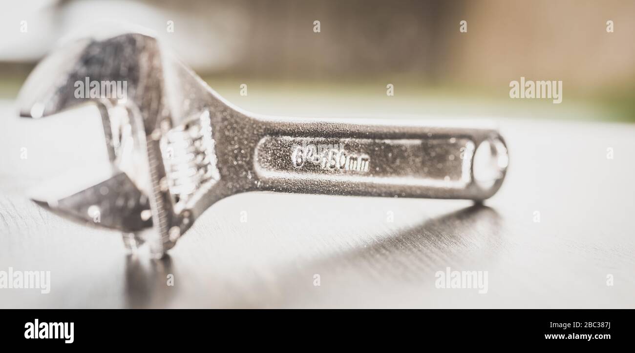 Wrench, French key, on blurred background Stock Photo - Alamy