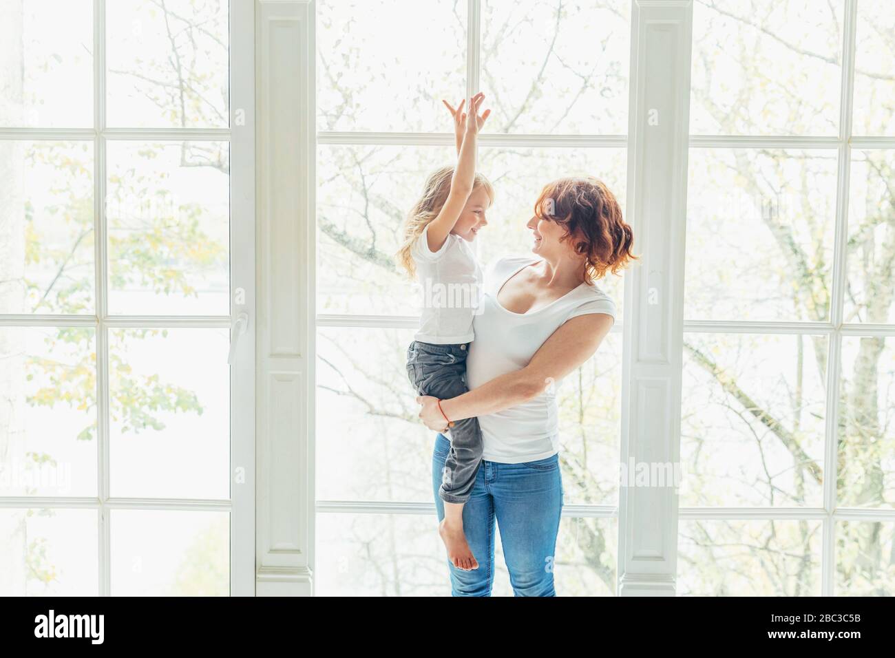 Stay Home Stay Safe. Young mother holding her child. Woman and little ...