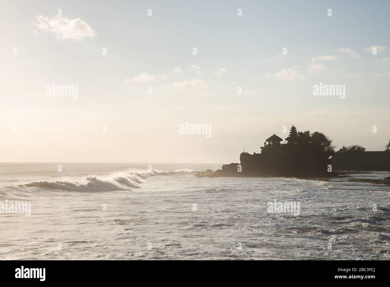 Backlit outline of Pura Tanah Lot Balinese sea temple with crashing ...