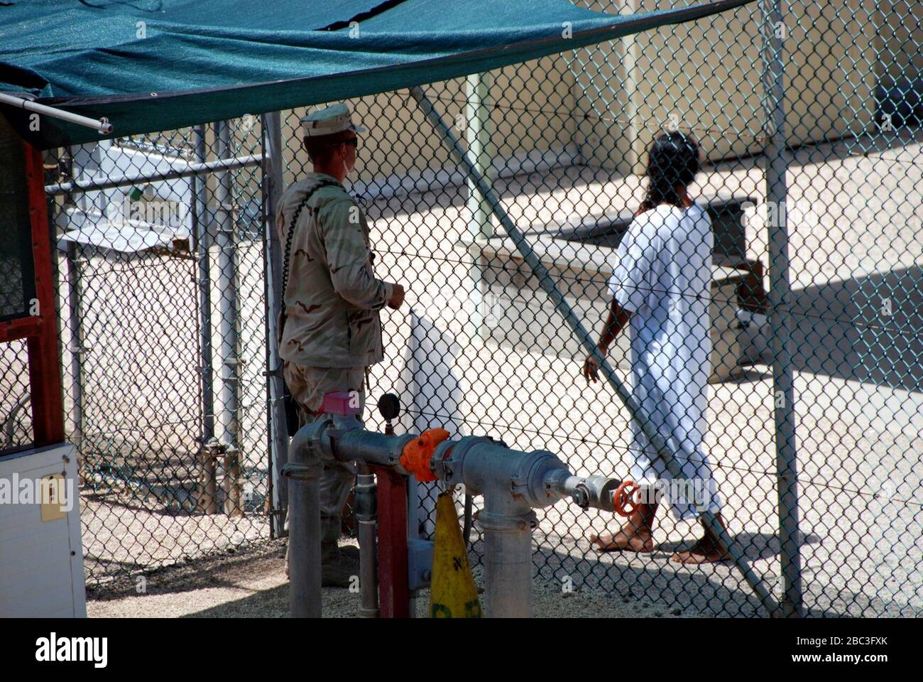 Guard talks with a captive in camp four -- the white uniform shows he ...