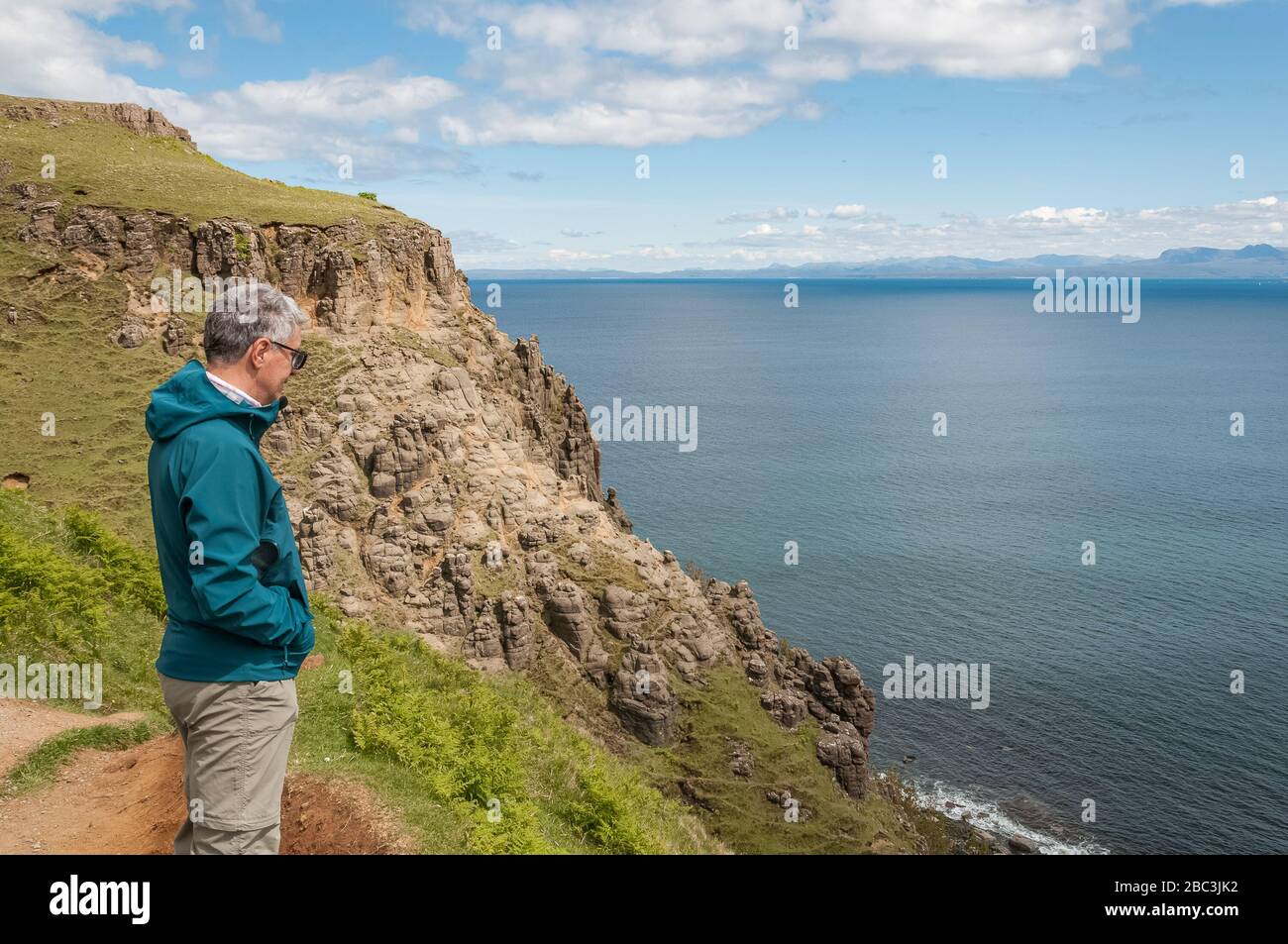Man with sporty look observing the cliff and the view from Lealt Fall ...