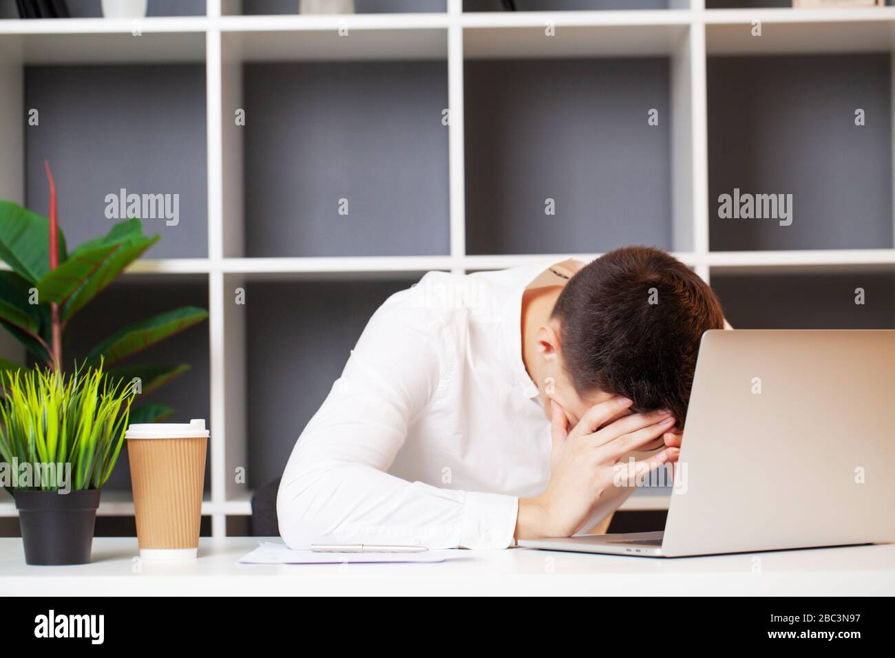 Tired man working at company office at computer Stock Photo - Alamy