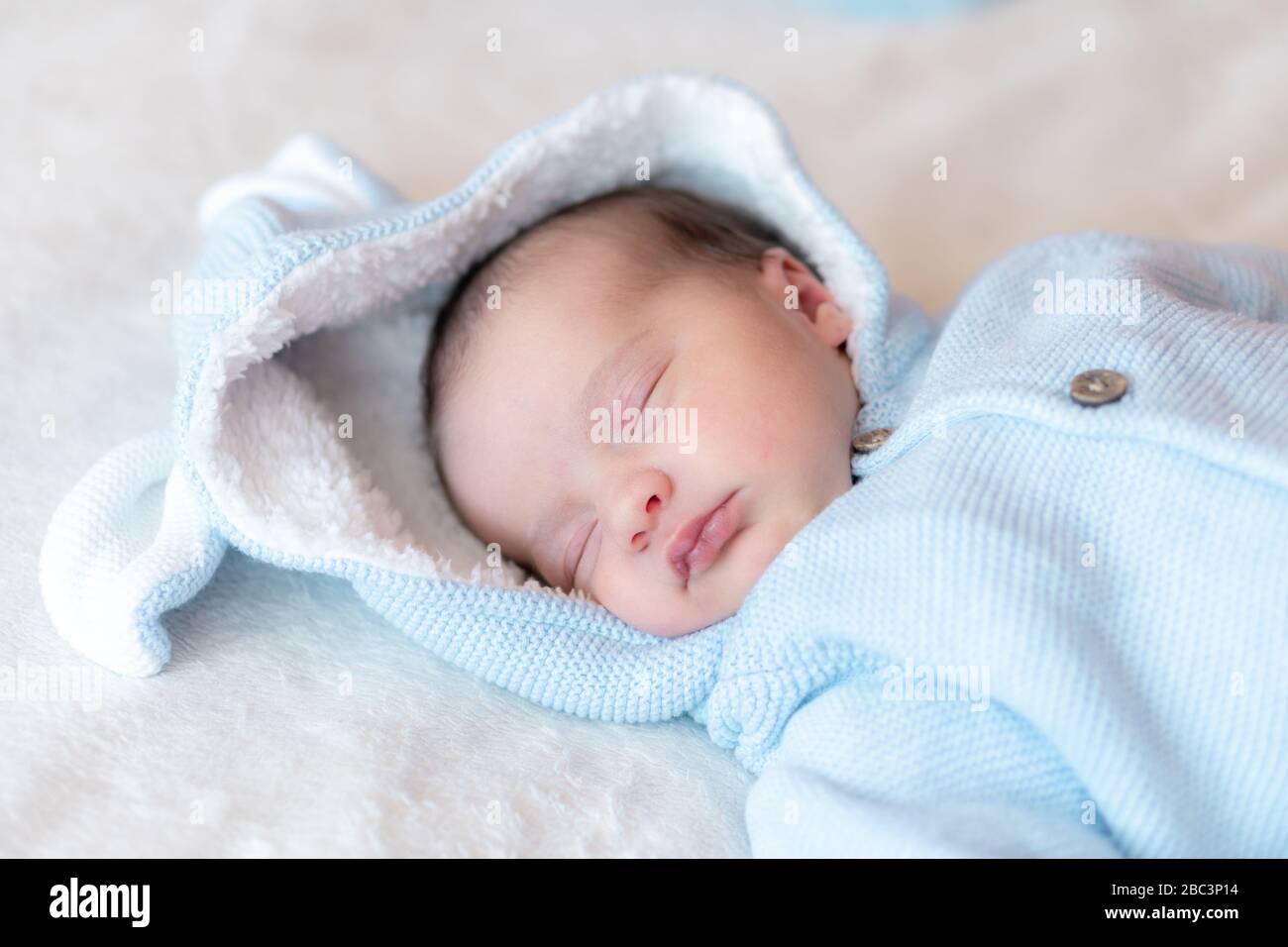 Newborn baby close-up. Side view of a newborn baby sleeping soundly on ...