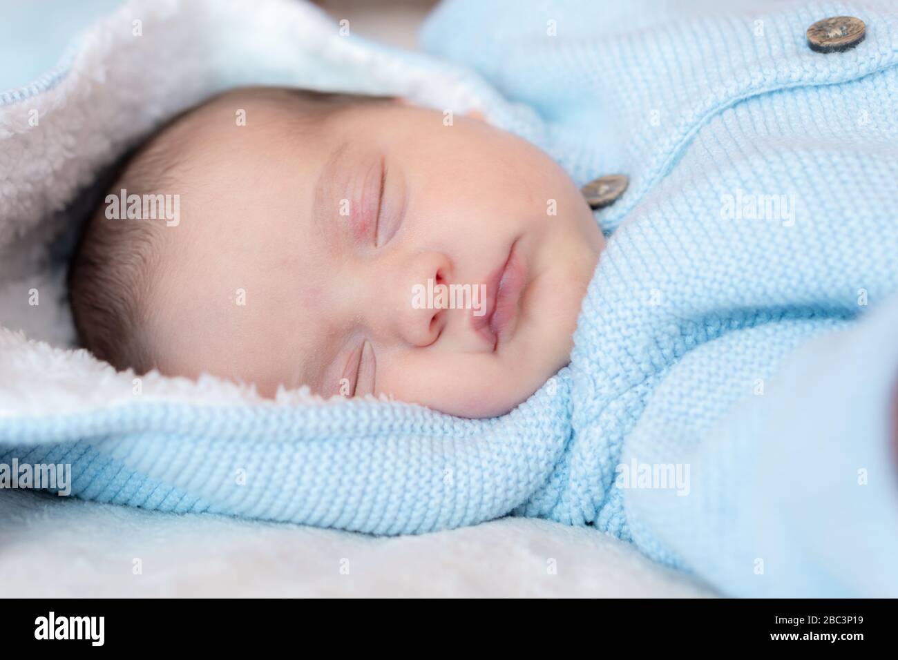 Newborn baby close-up. Side view of a newborn baby sleeping soundly on ...