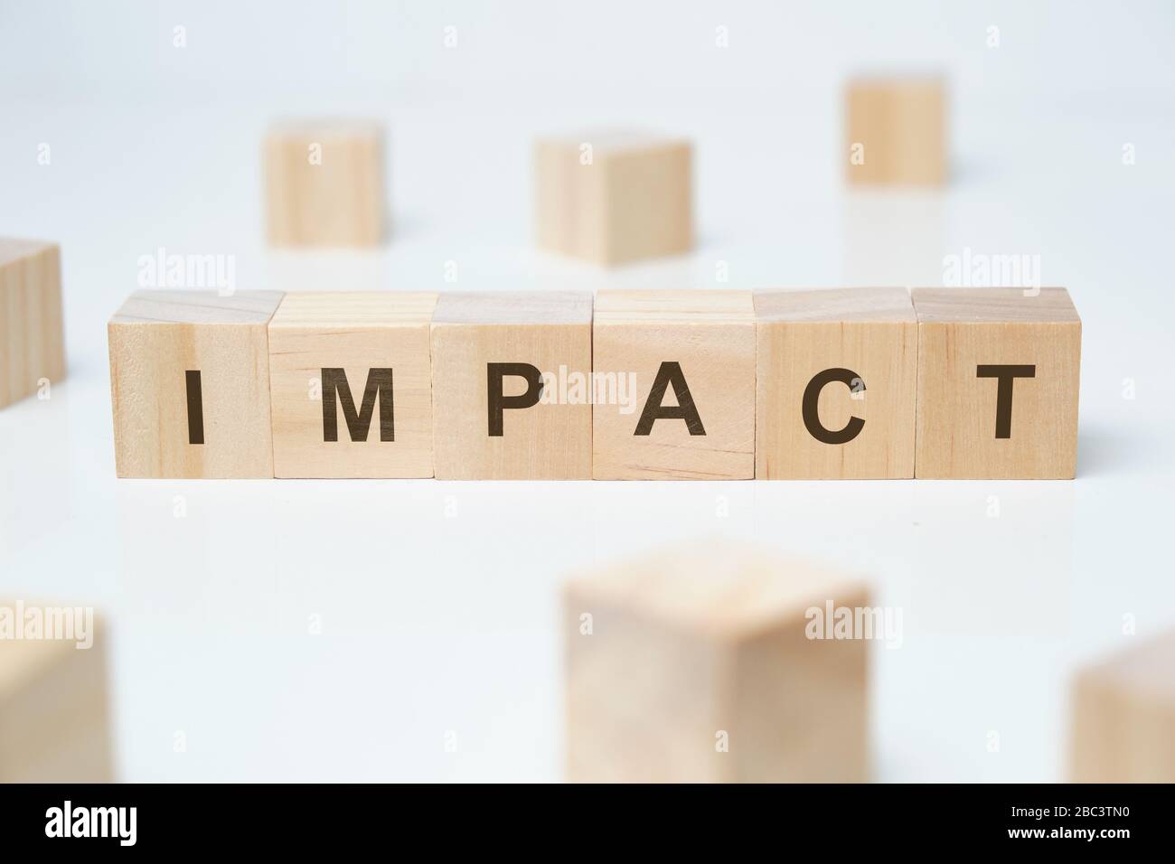 Modern business buzzword - impact. Word on wooden blocks on a white ...