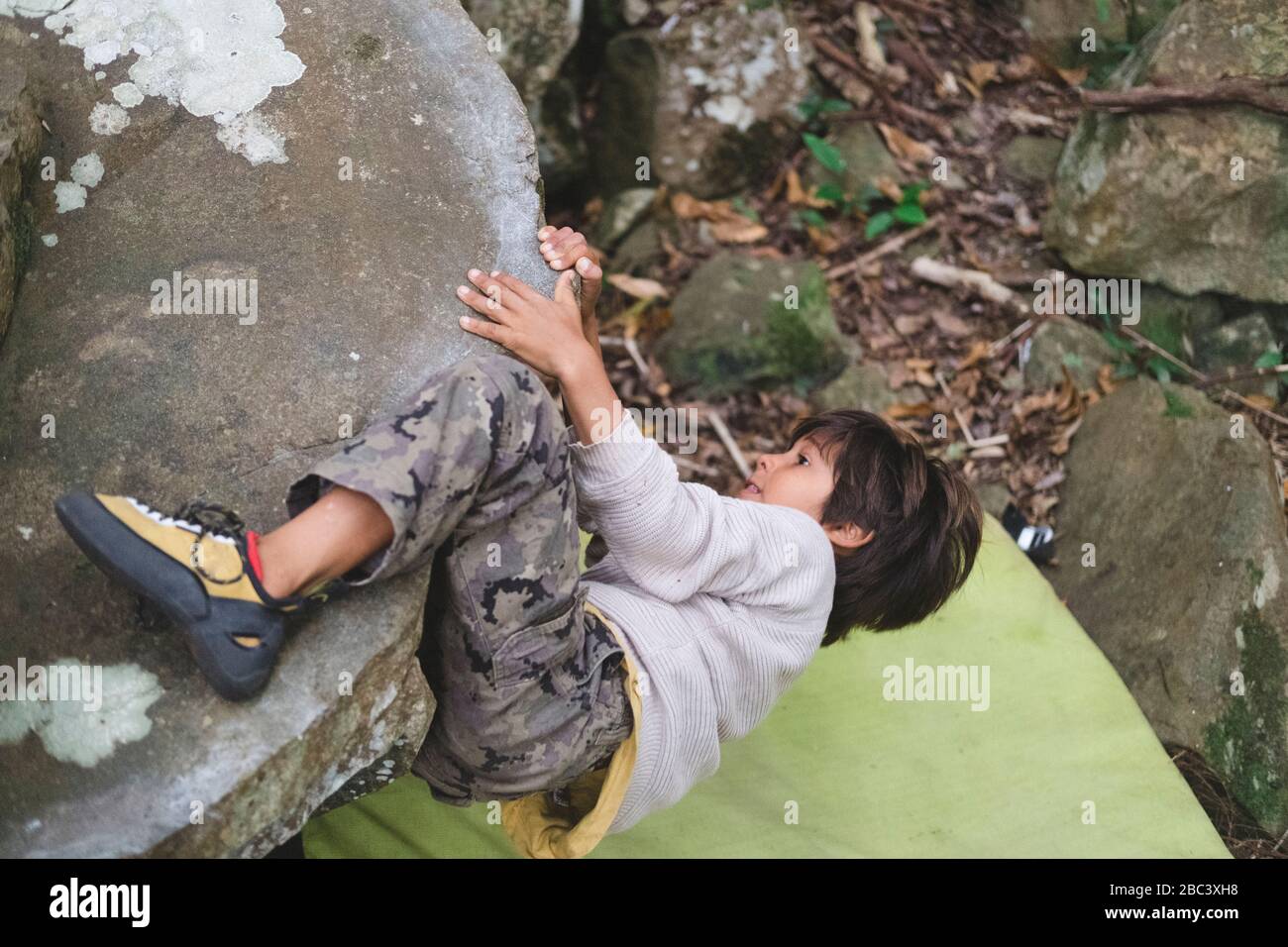 Little boy climbing a boulder outdoors Stock Photo - Alamy