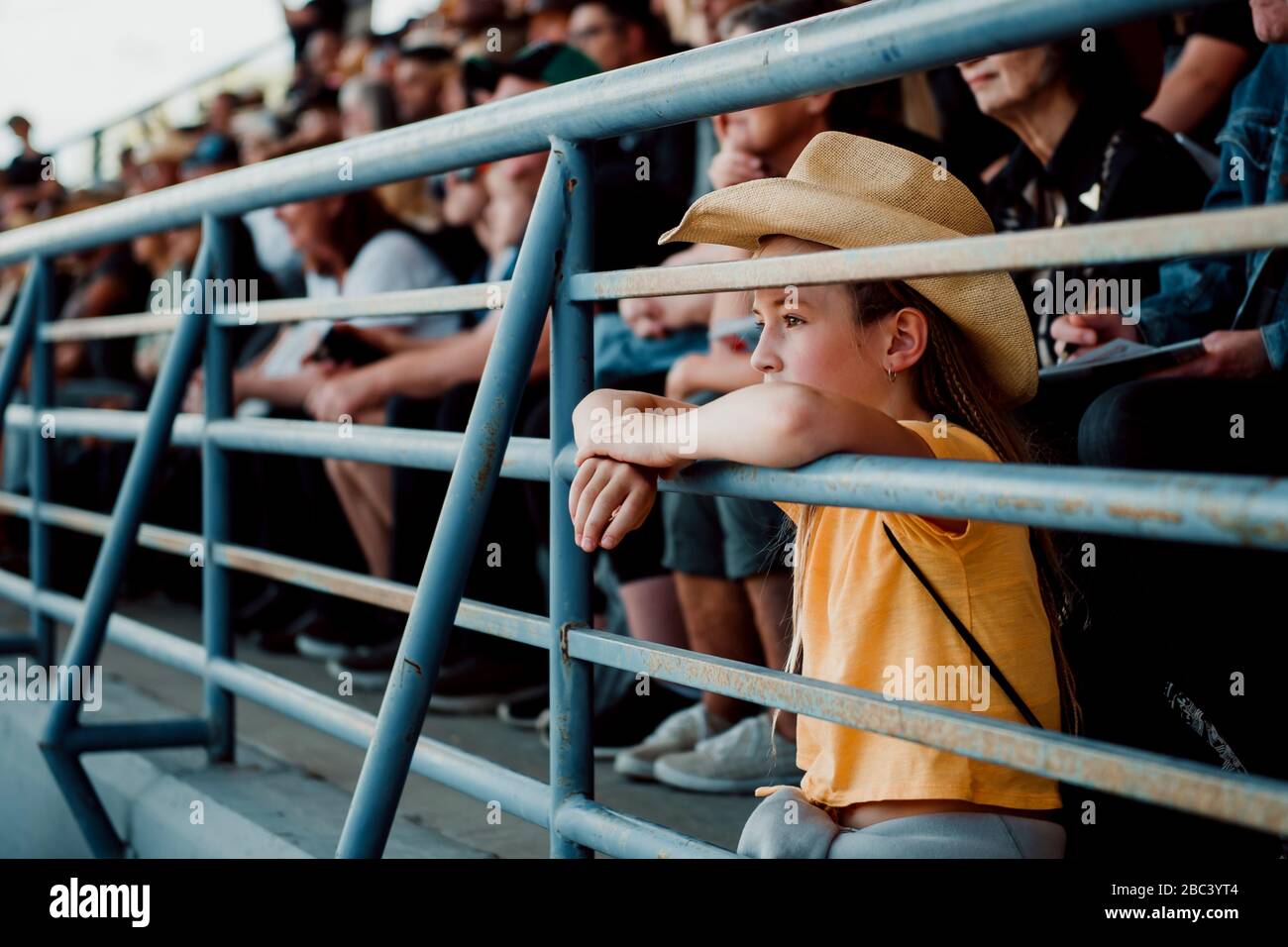 Little girl watching the rodeo with a cowboy hat on Stock Photo - Alamy