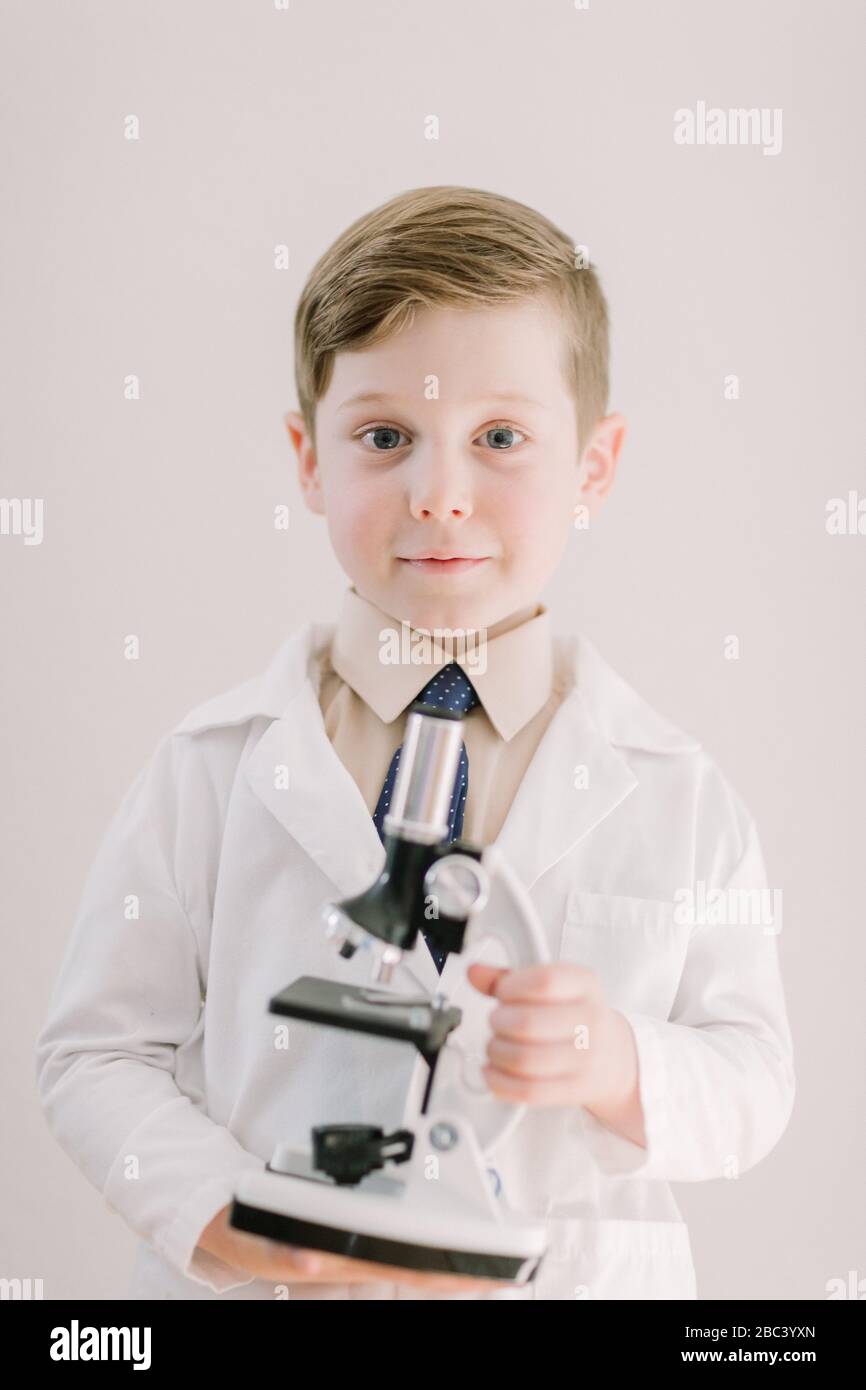 Young child holding a microscope smiling at camera Stock Photo - Alamy