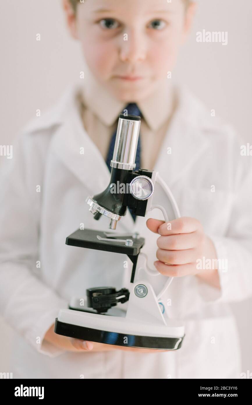 Child in labcoat holding a science microscope Stock Photo - Alamy
