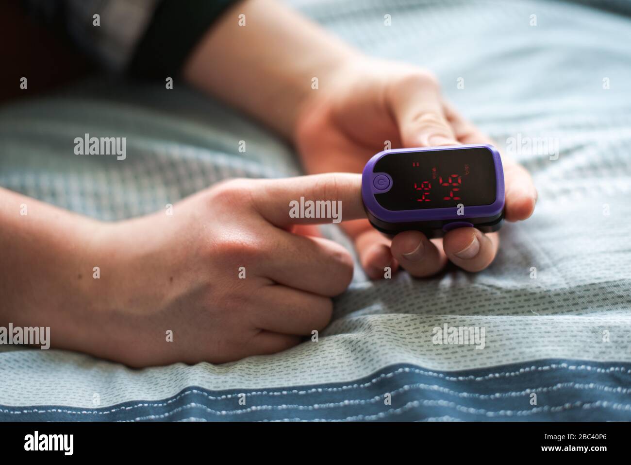 Close up of a person putting a pulse oximeter on their finger Stock ...