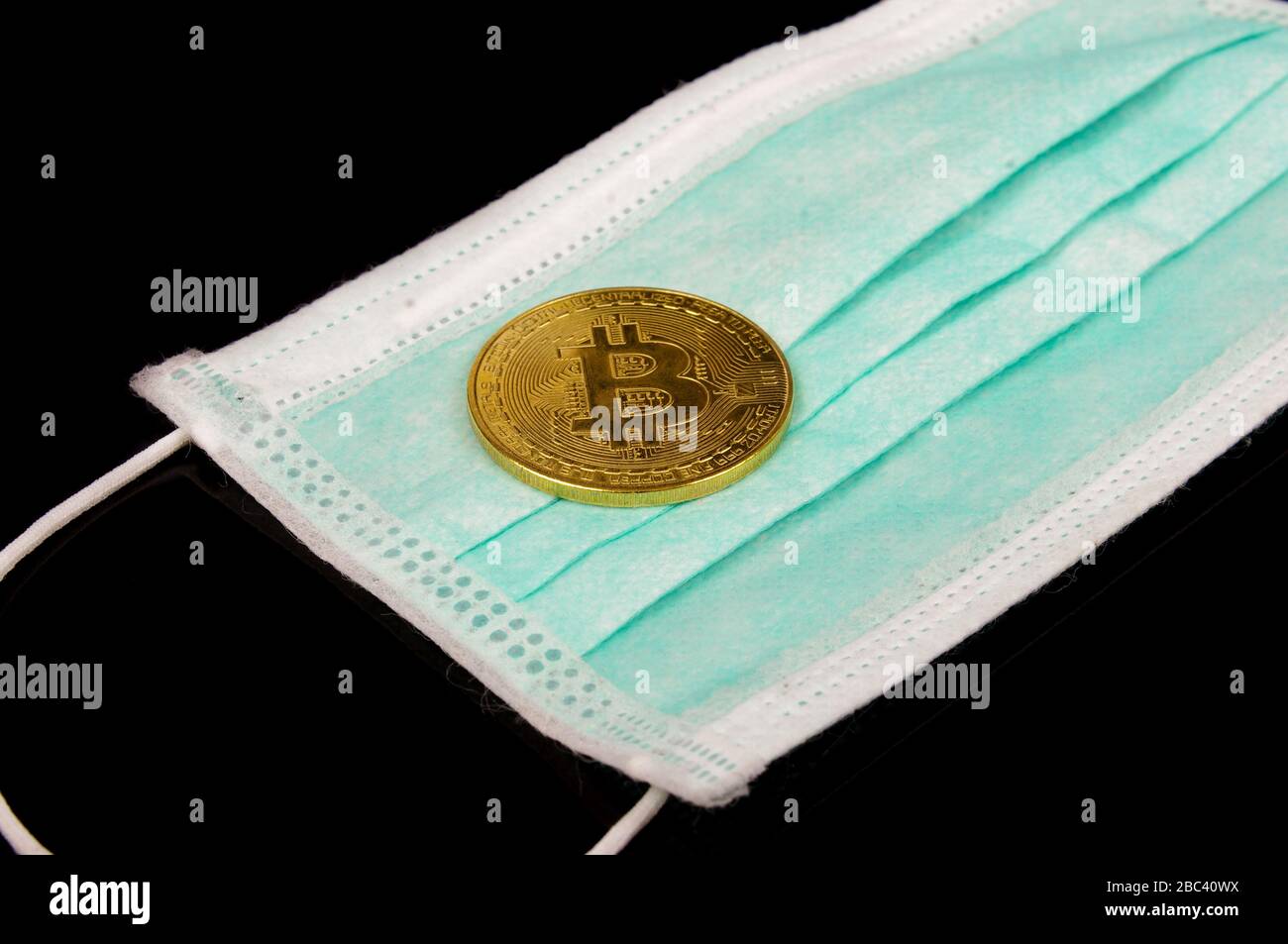 Bitcoin symbolic coin on the face mask isolated on the black background ...