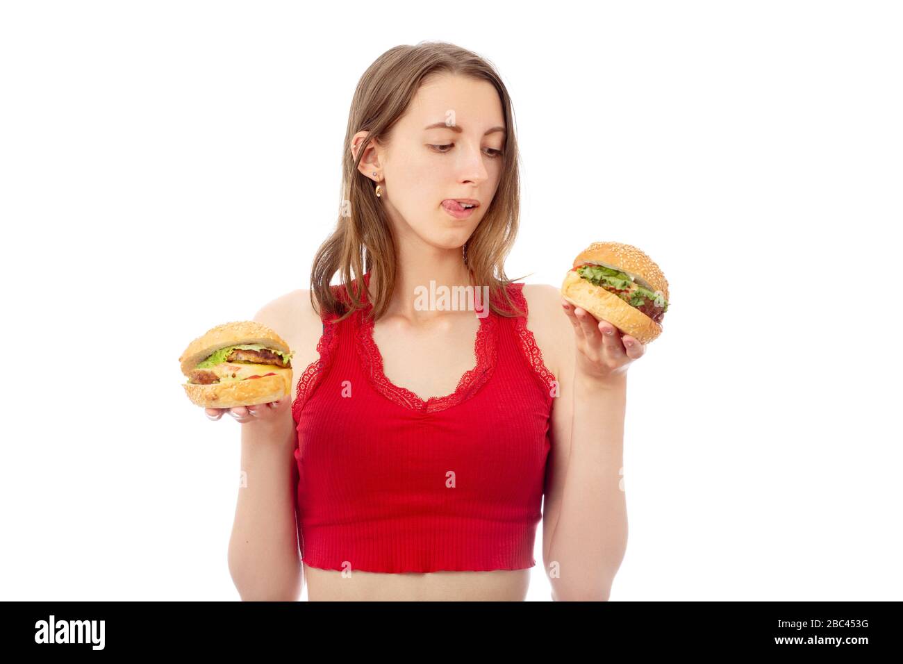 hungry young woman looks on cheeseburgers on white background isolated ...