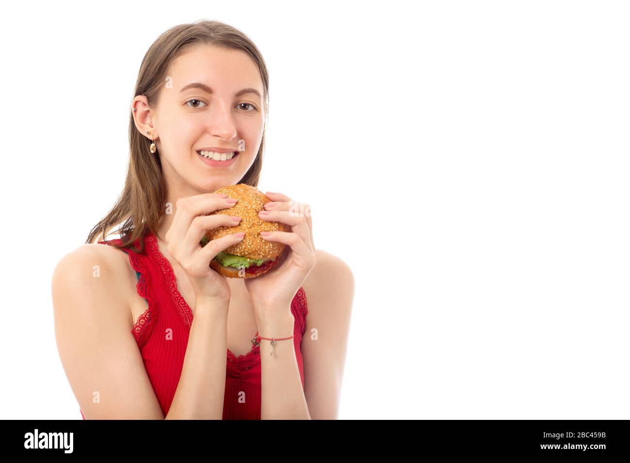 happy young woman eats cheeseburger on white background isolated ...