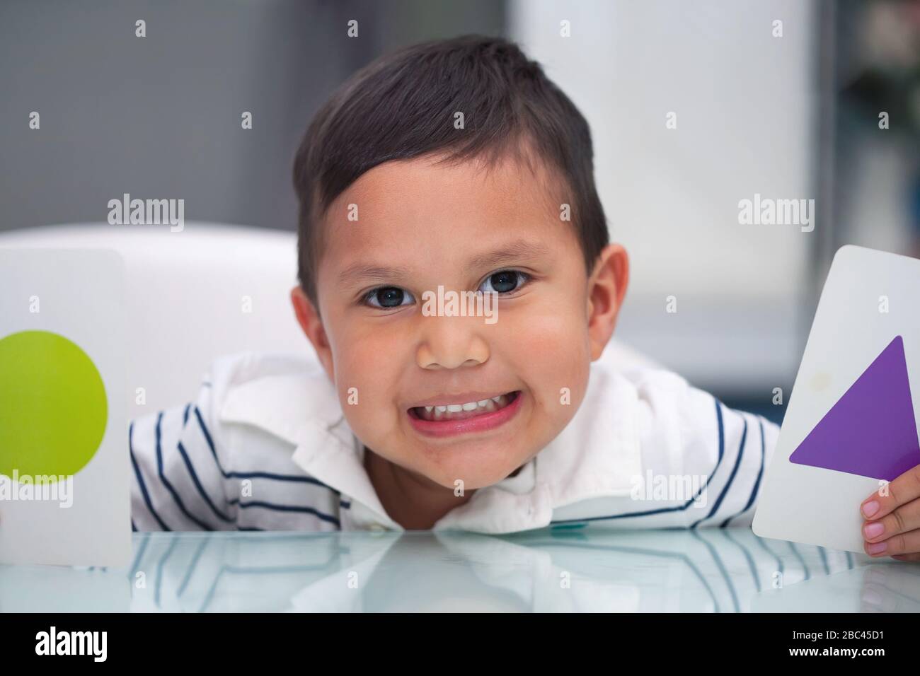 Little boy of preschool age is learning at home using basic shape flash ...