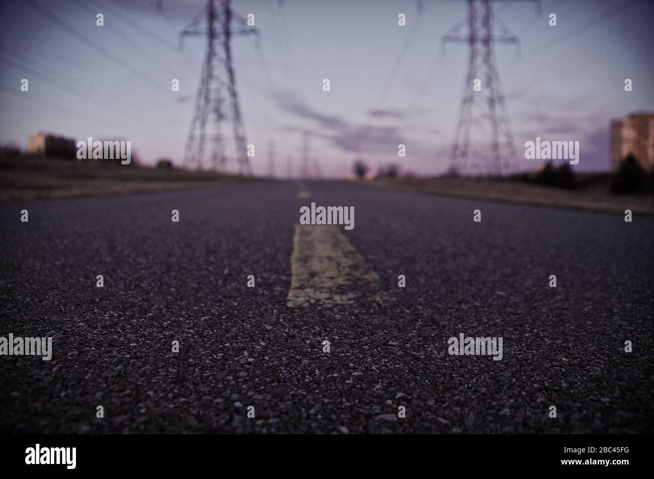 Closeup view of black asphalt road with faded dash lines in front of ...