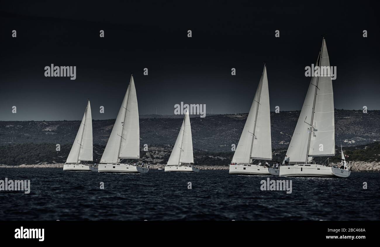 Sailboats compete in a sailing regatta at sunset, sailing race ...