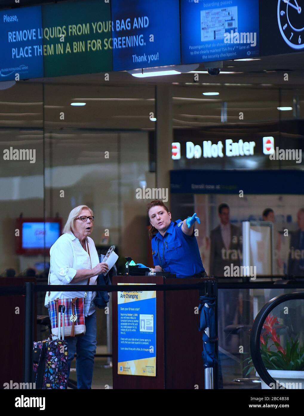 A TSA officer wears protective gloves while screening travellers at ...