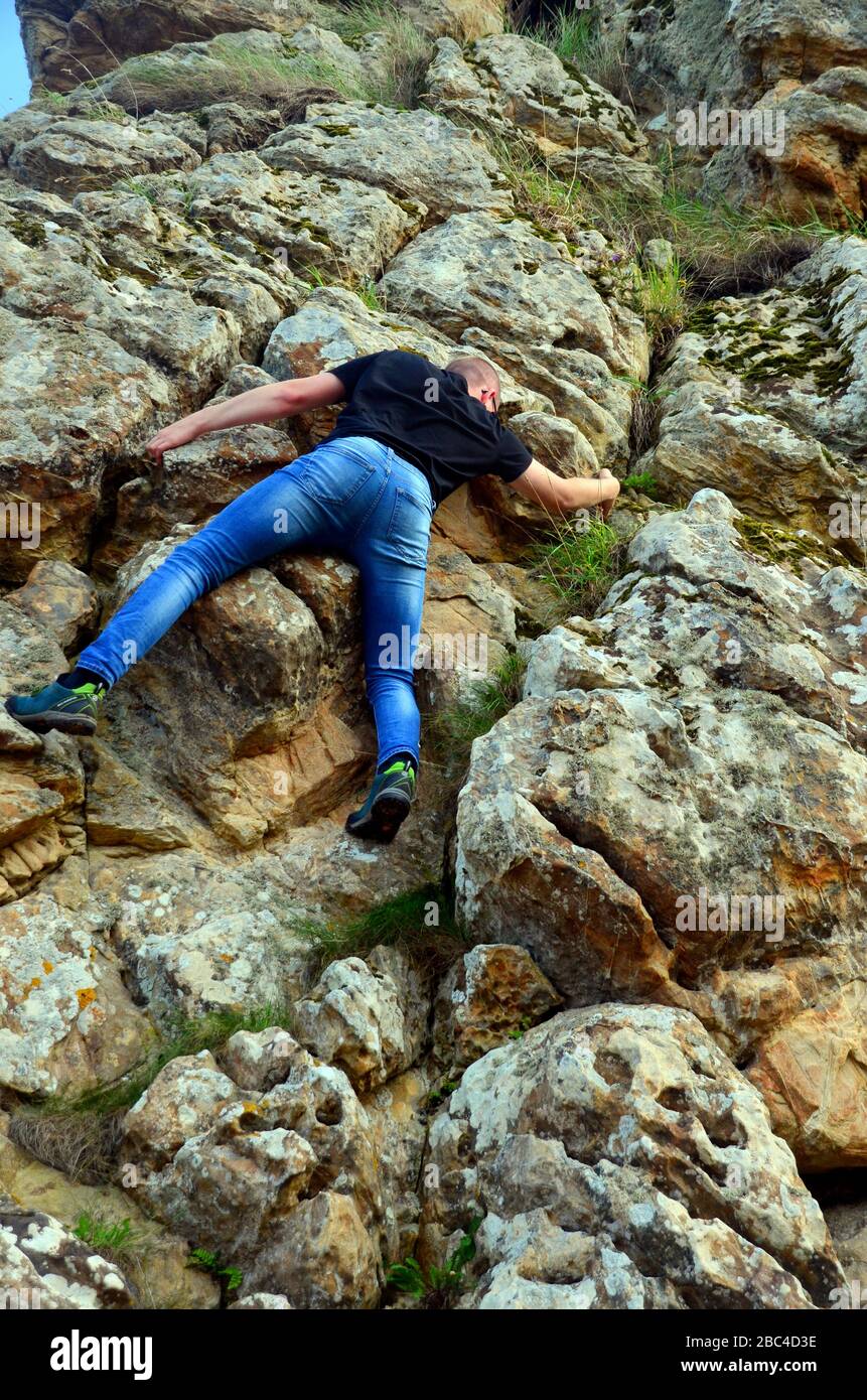 Man climbing cliff face hi-res stock photography and images - Alamy
