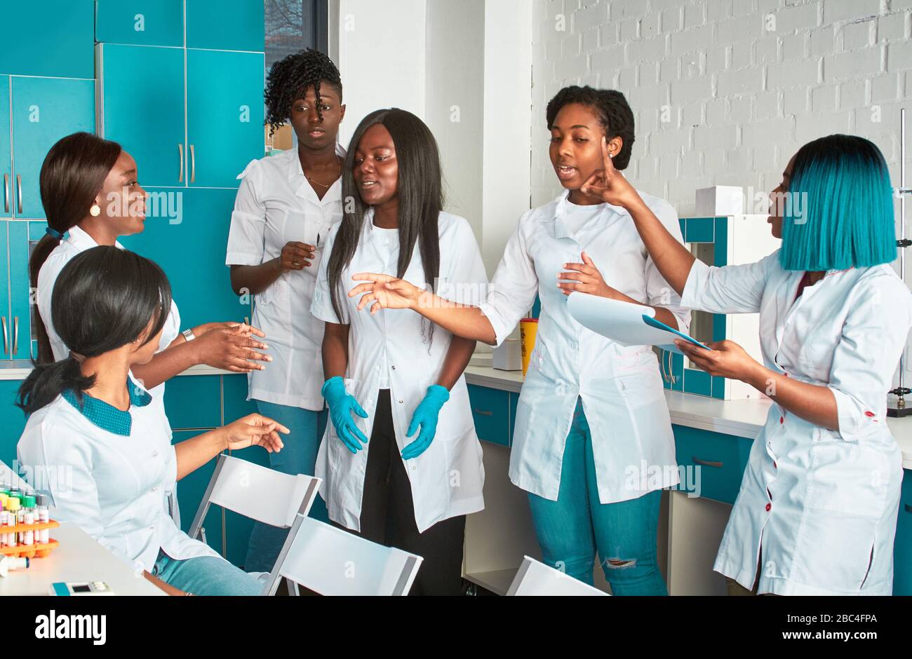 Female African medical students, young graduates or doctors discuss ...