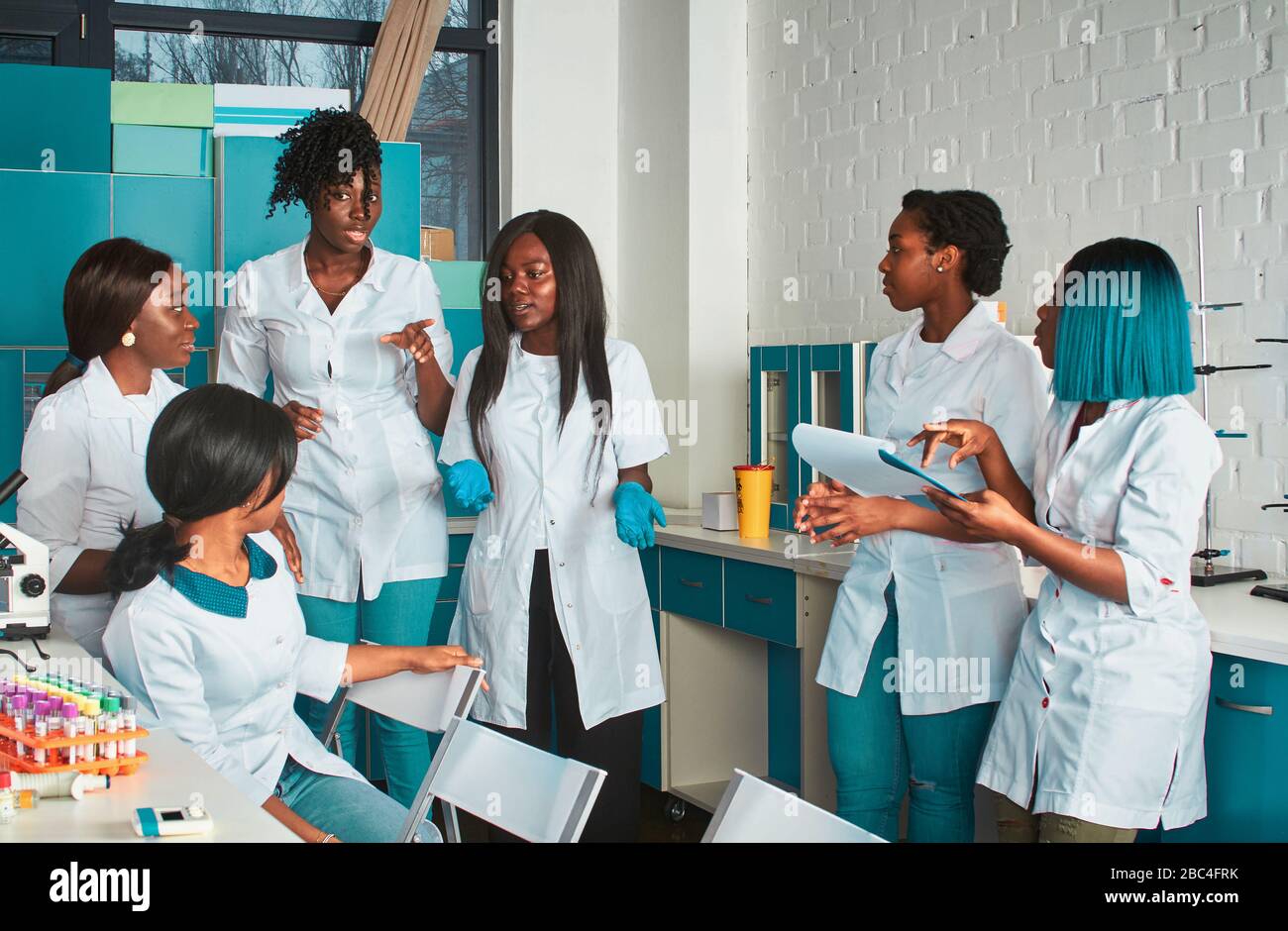 Female African medical students, young graduates or doctors discuss ...