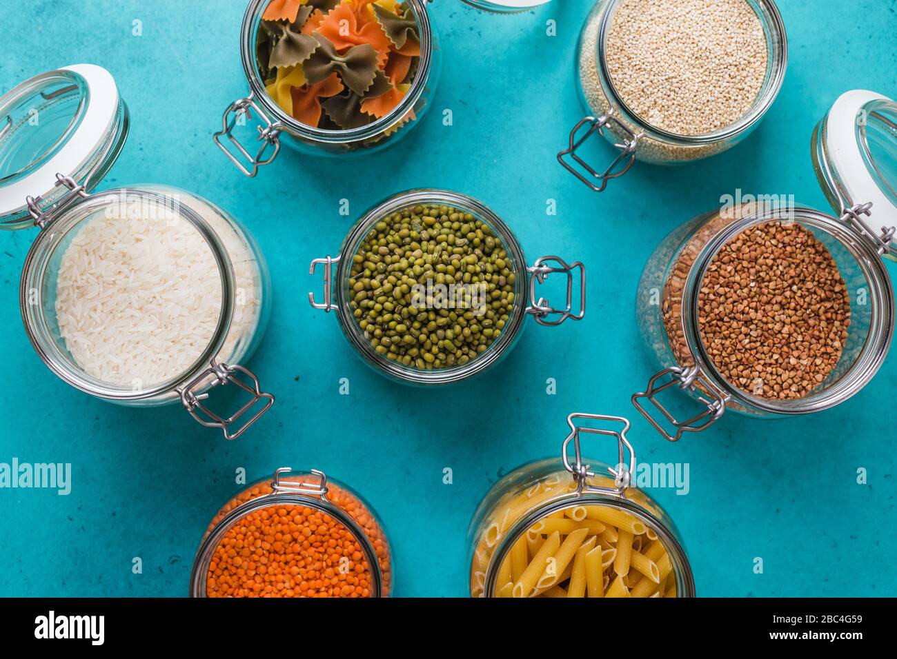 Glass boxes and bottles with quinoa, lentil, buckwheat, rice, mash ...