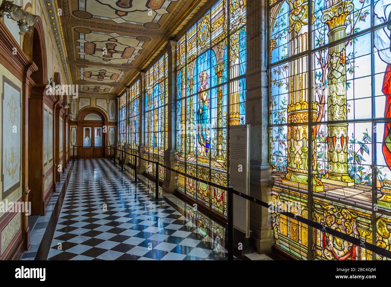 Hallway lined with ornate stain glass murals, at Chapultepec Castle, in ...