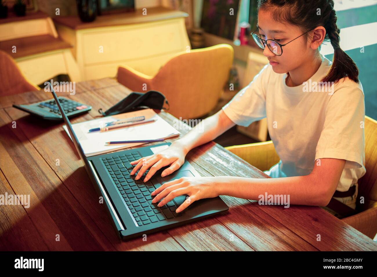 asian teenager working on computer laptop in home living room ,concept ...