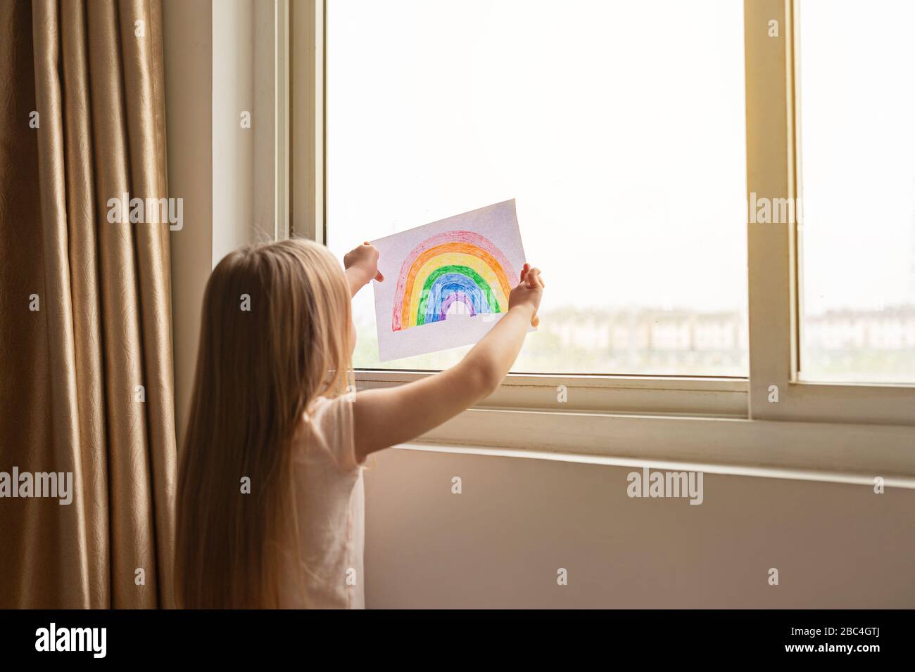 Kid painting rainbow during Covid-19 quarantine at home. Stay at home ...