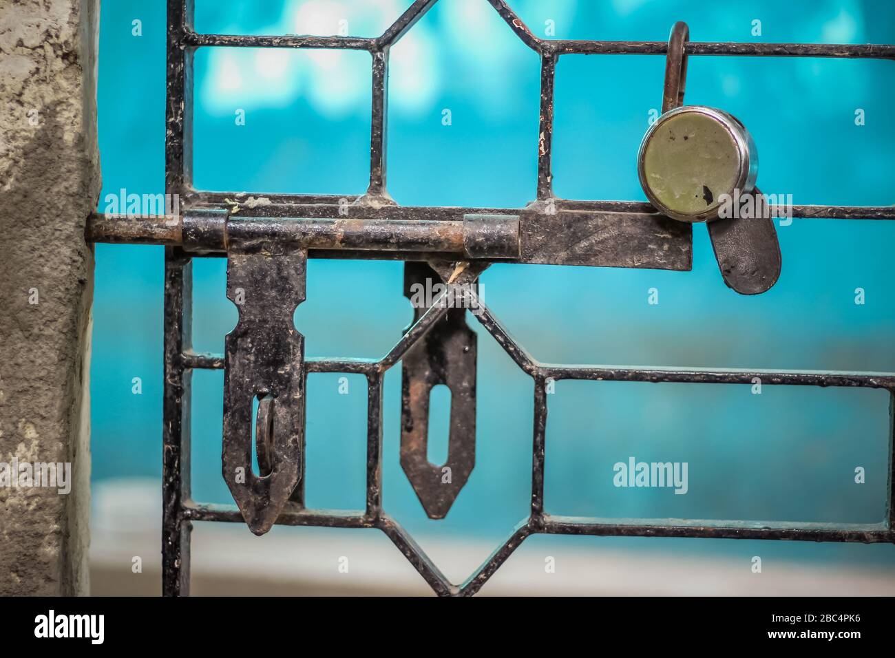 Iron rod gate with Lock and Key on blue background Stock Photo - Alamy