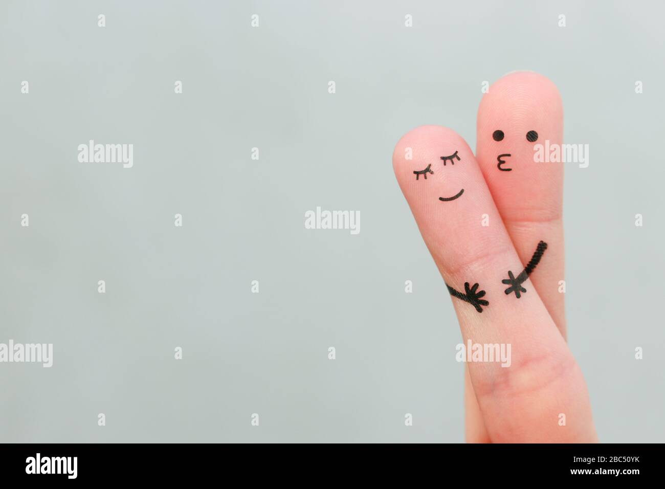 Fingers art of Happy couple. Man hugs and kisses woman Stock Photo - Alamy