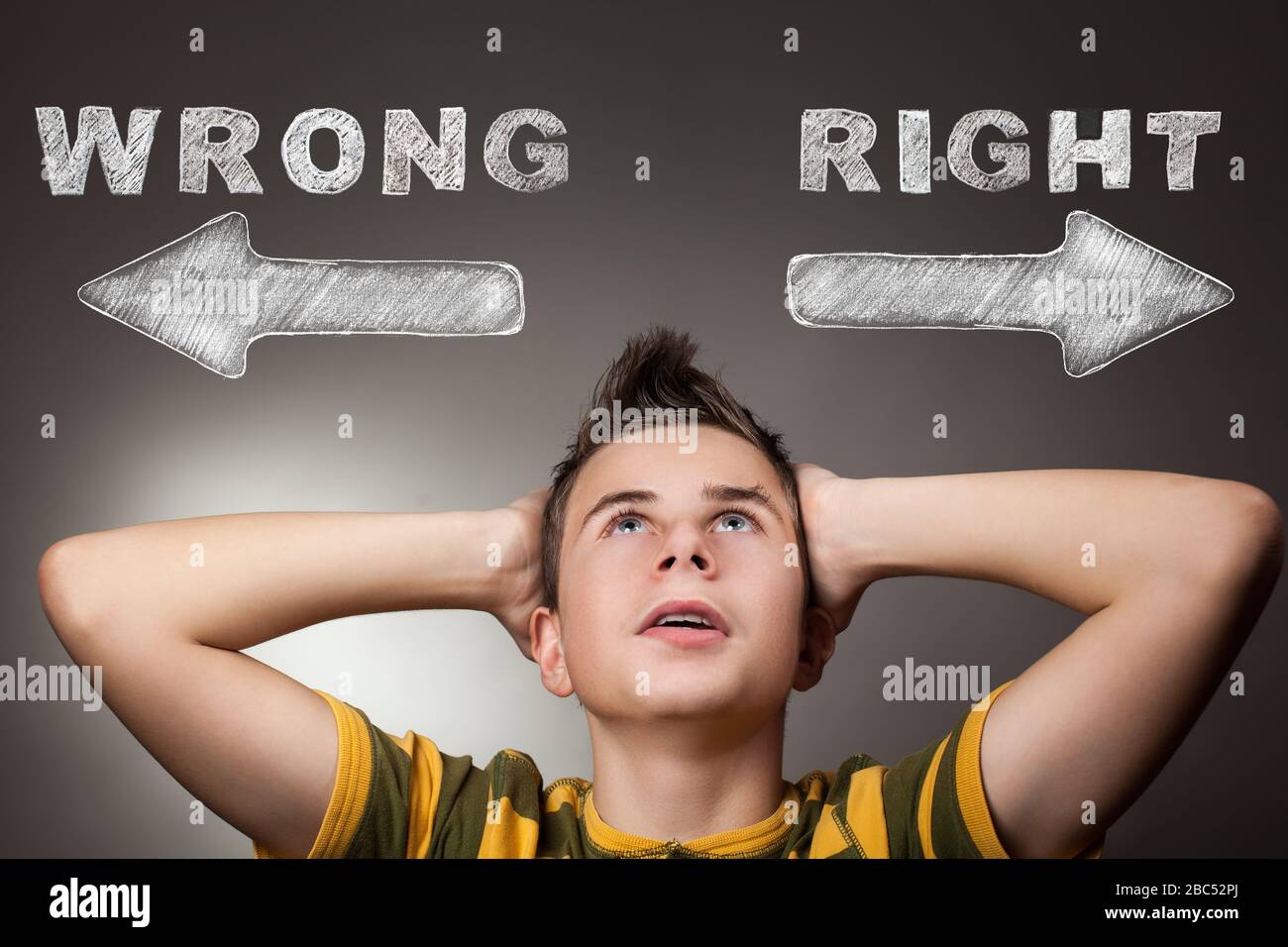 Young boy looking up at wrong and right words Stock Photo - Alamy