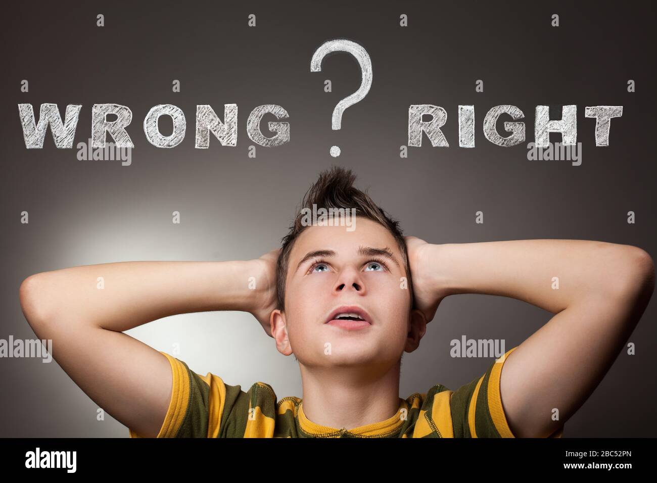 Young boy looking up at wrong and right words Stock Photo - Alamy