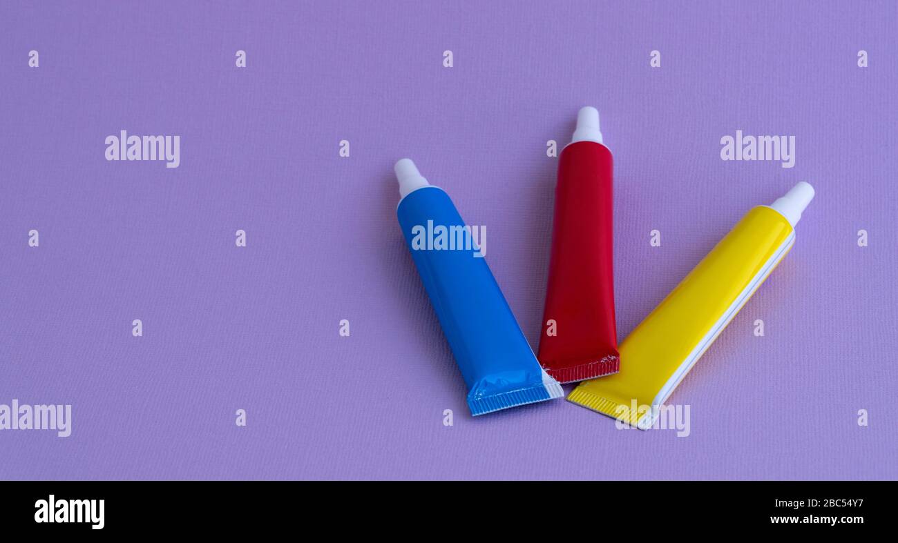 tubes of food dye on a purple background. multicolored food coloring ...