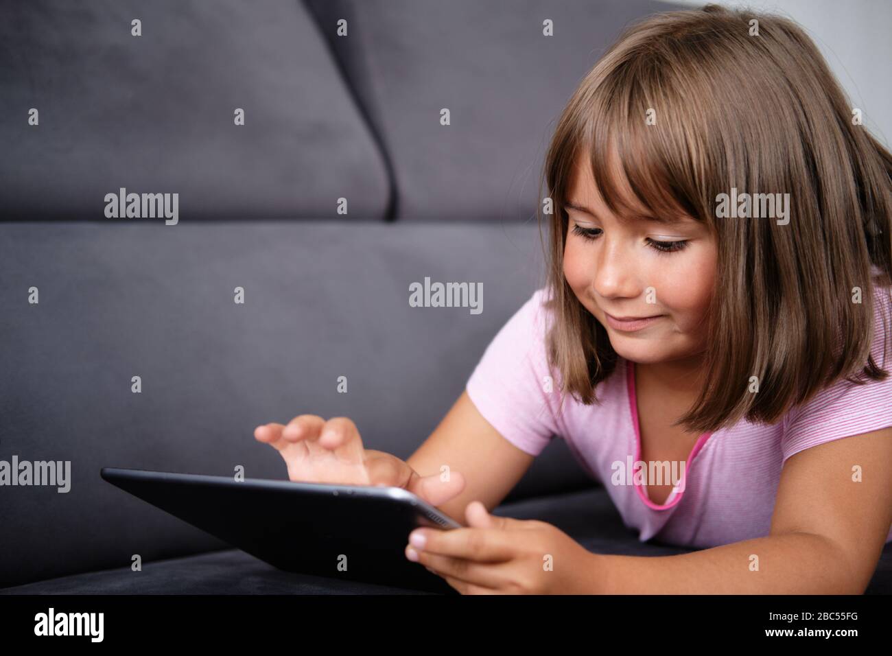 Preschool Girl Draws on the Tablet. Little girl play with tablet Stock ...