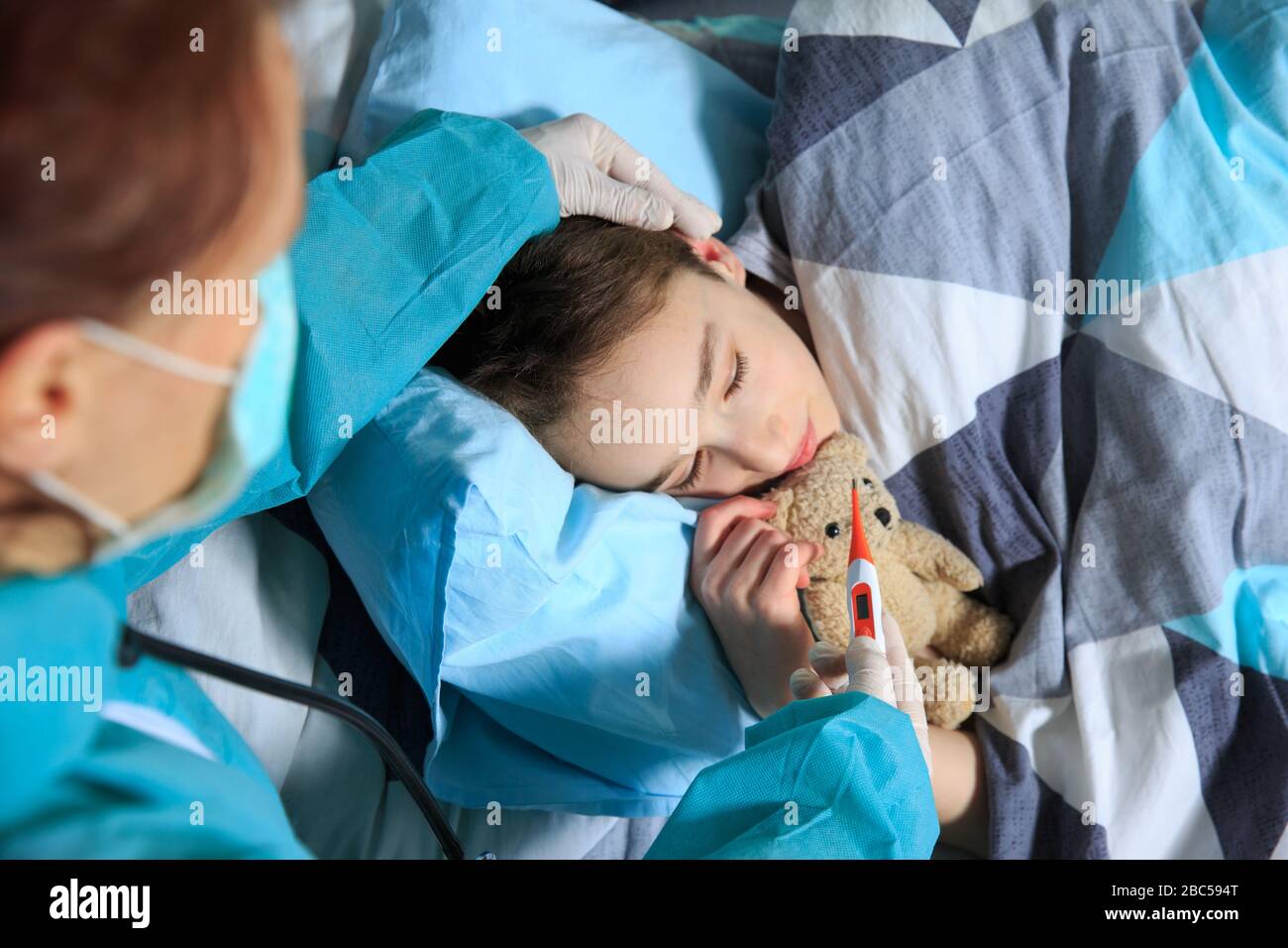 Sick boy with thermometer laying in bed. Sick child with fever and ...