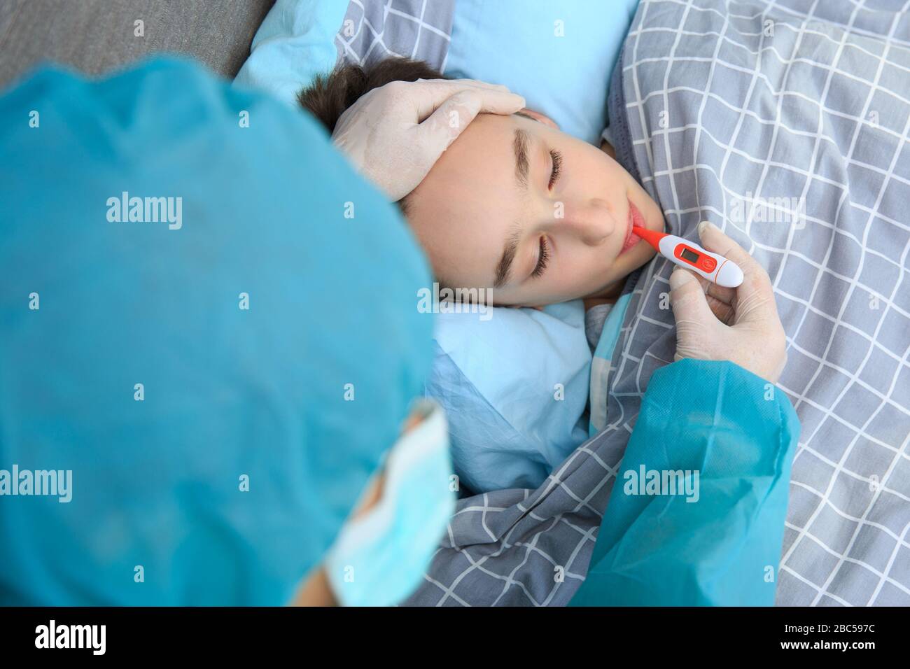 Sick boy with thermometer laying in bed. Sick child with fever and ...
