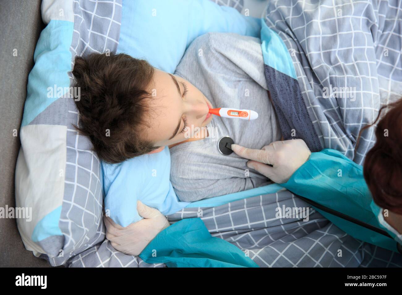 Sick boy with thermometer laying in bed. Sick child with fever and ...