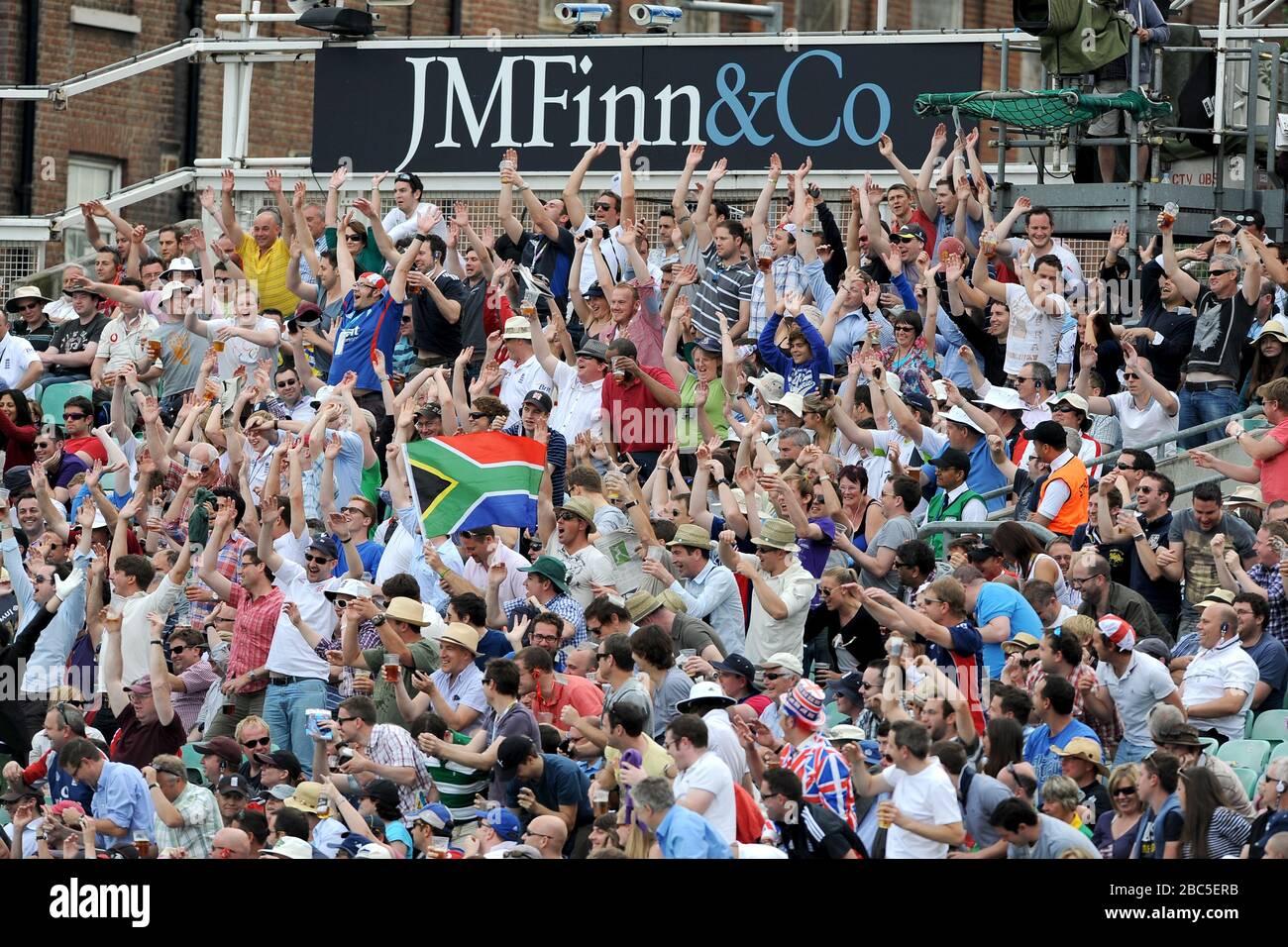 Fans enjoy a Mexican wave in the stands Stock Photo - Alamy