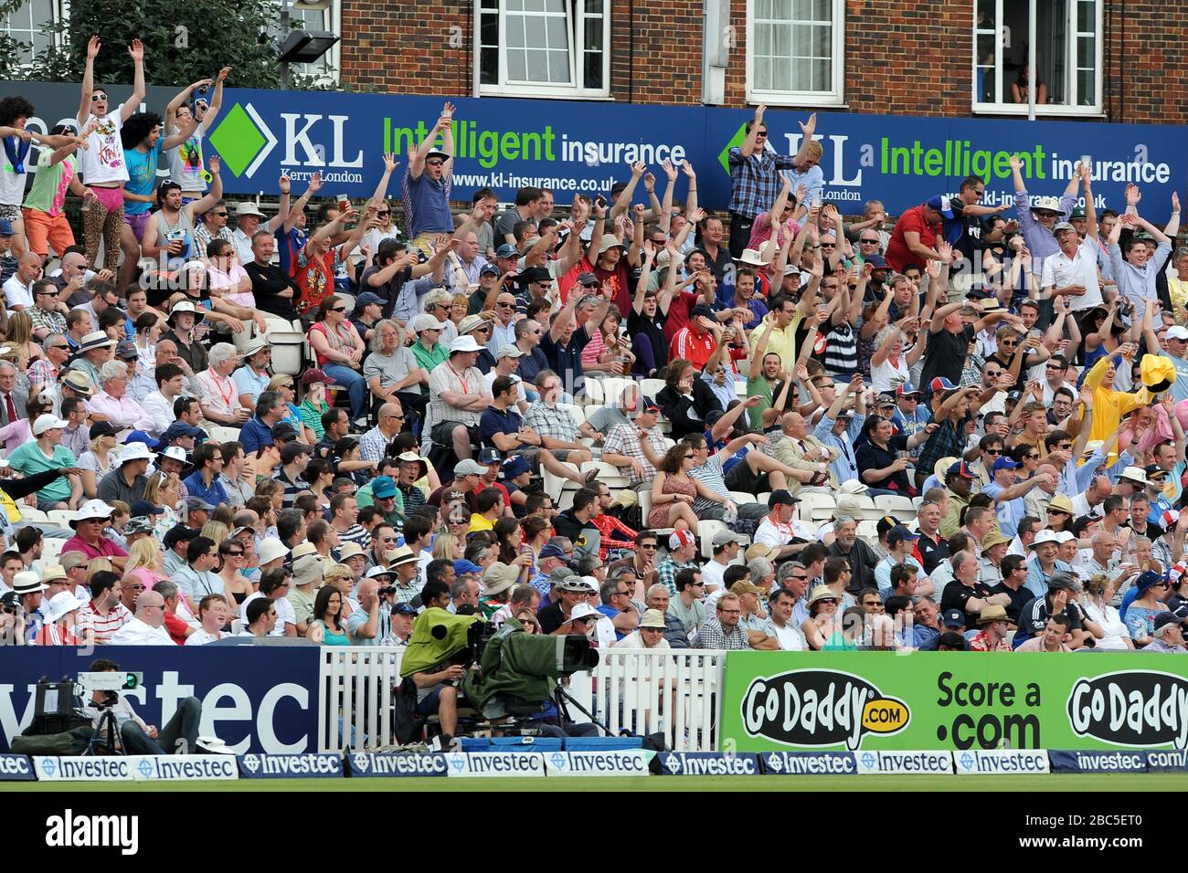 Fans enjoy a Mexican wave in the stands Stock Photo - Alamy
