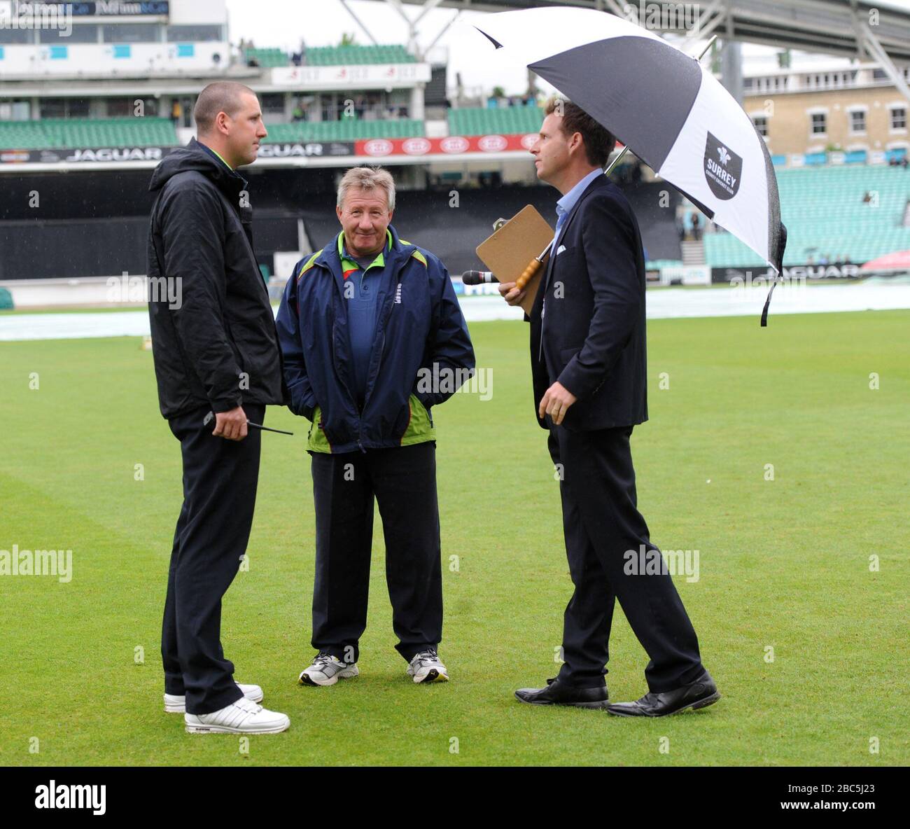 Umpires Nigel Cowley (centre) and Michael Gough talk with the Surrey on ...