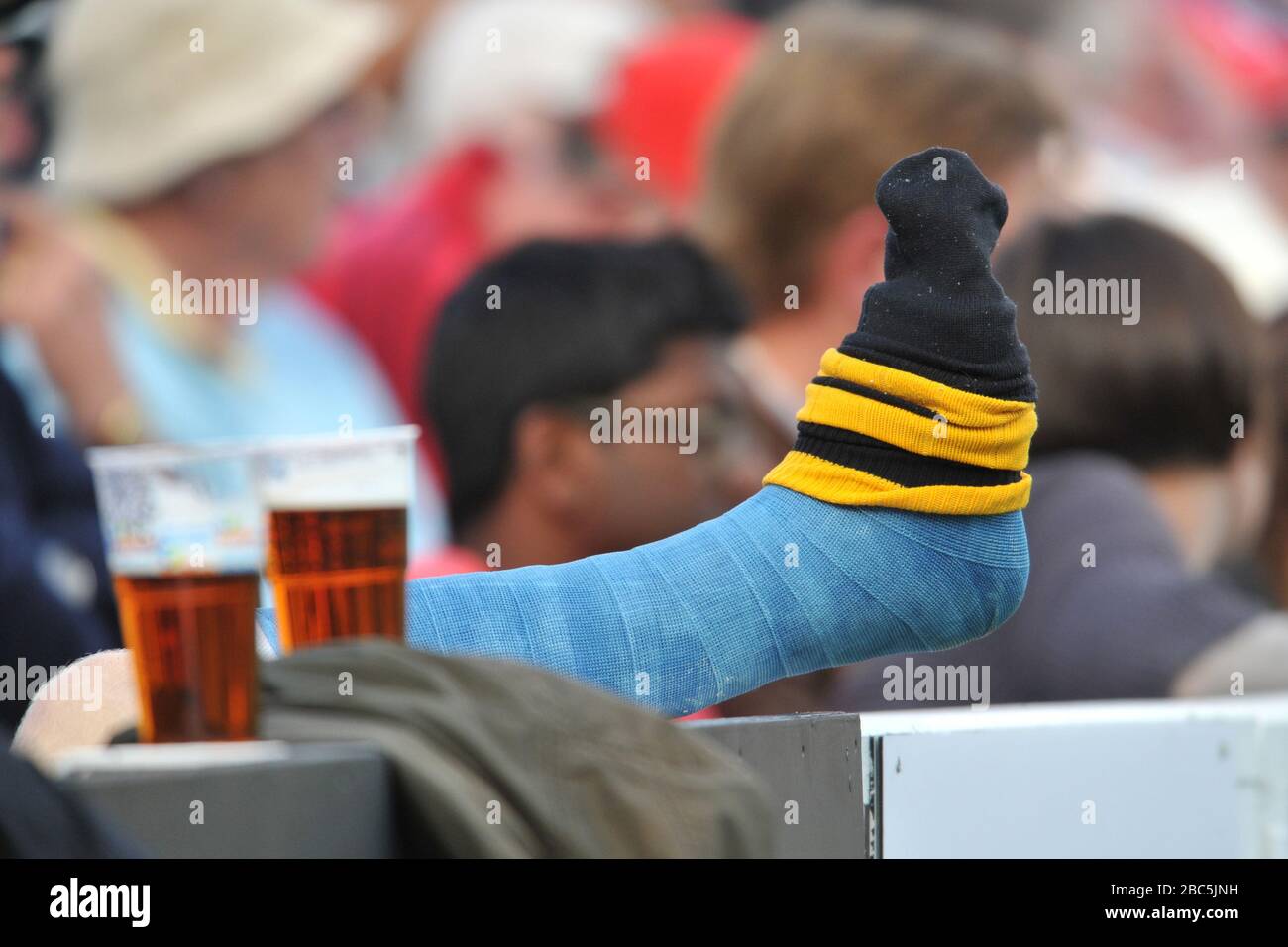 A spectator wears a cast in the stands Stock Photo - Alamy
