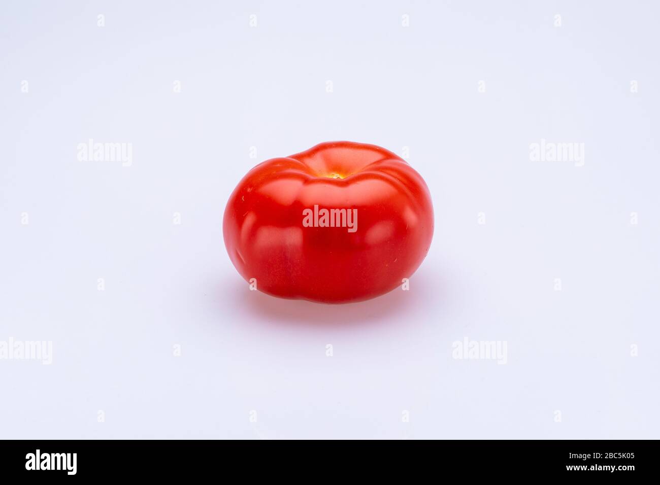 Red tomatoe in front of a white background Stock Photo - Alamy