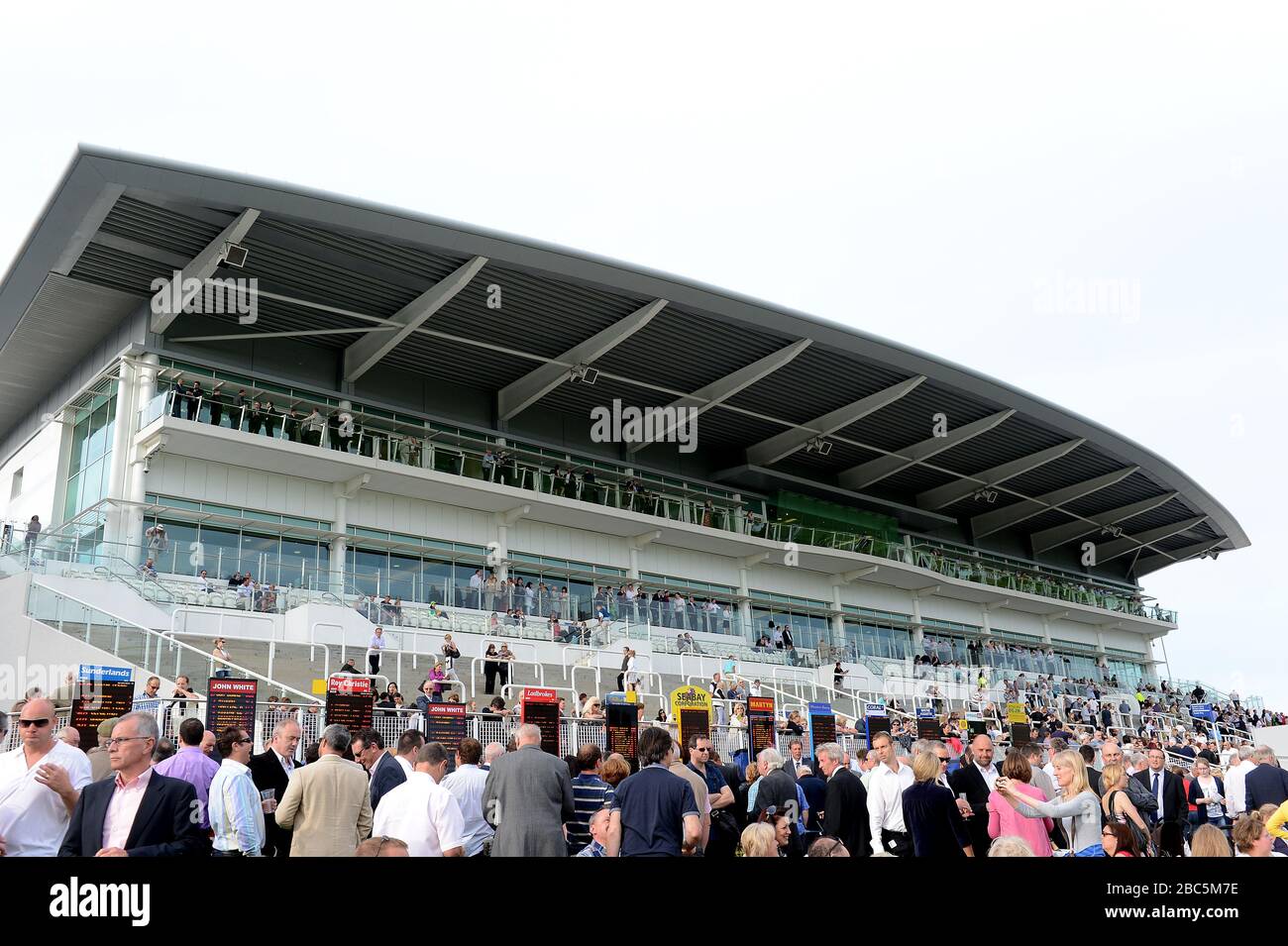 Racegoers watch the action at Epsom Racecourse Stock Photo - Alamy