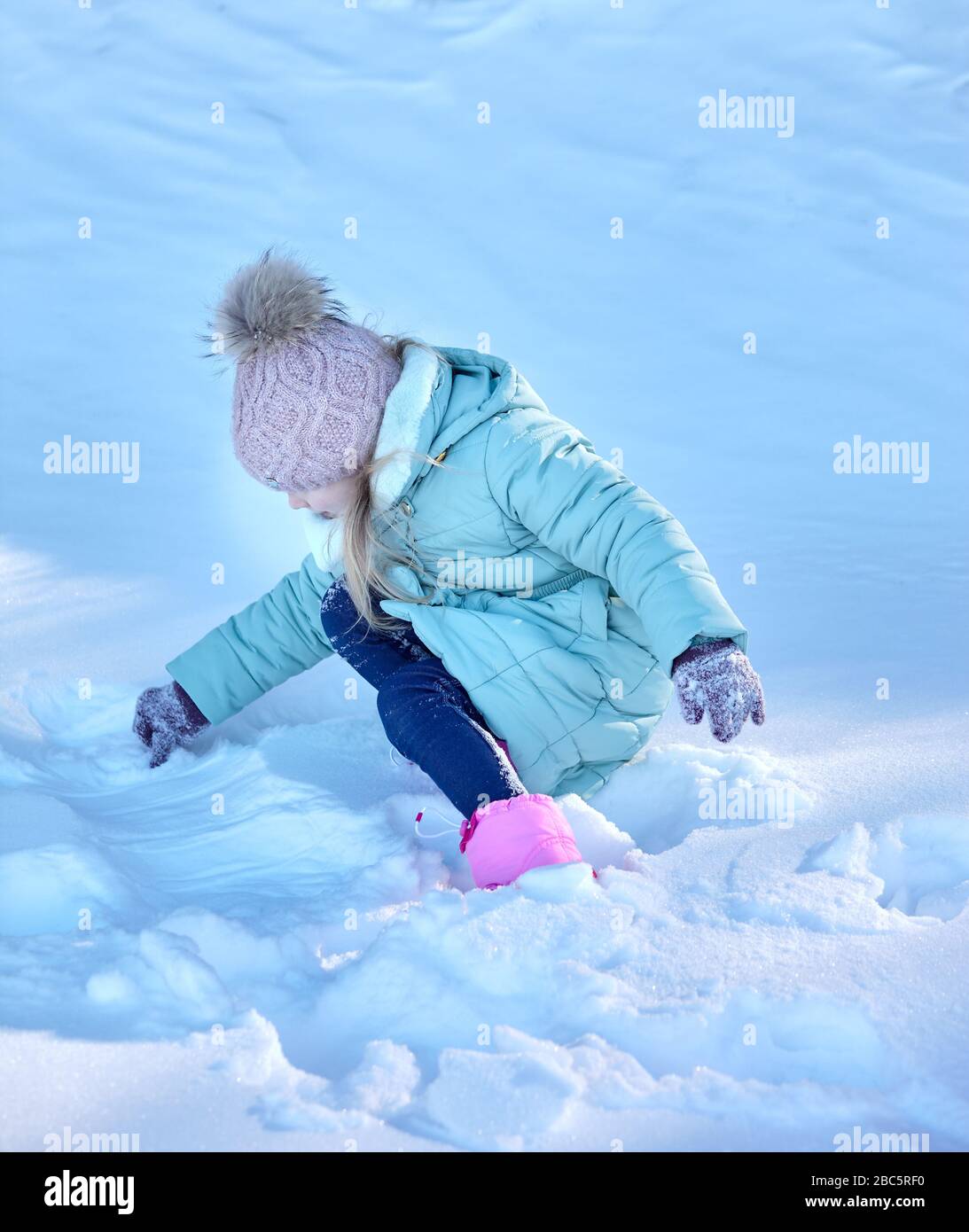 Little kid girl in colorful clothes playing outdoors. Active leisure ...