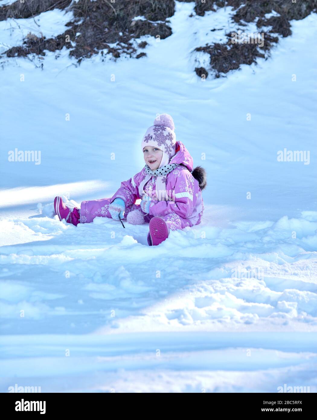 Little kid girl in colorful clothes playing outdoors. Active leisure ...