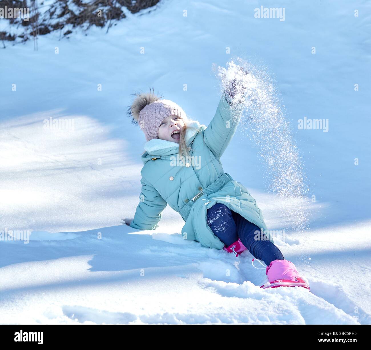 Little kid girl in colorful clothes playing outdoors. Active leisure ...