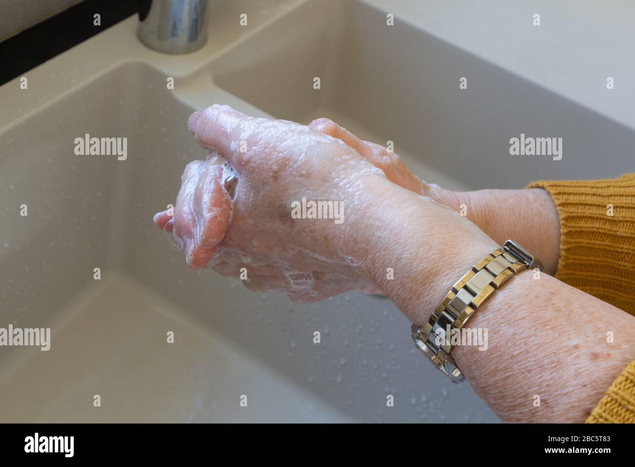 Woman washing her hand with soap in a bathroom Stock Photo - Alamy
