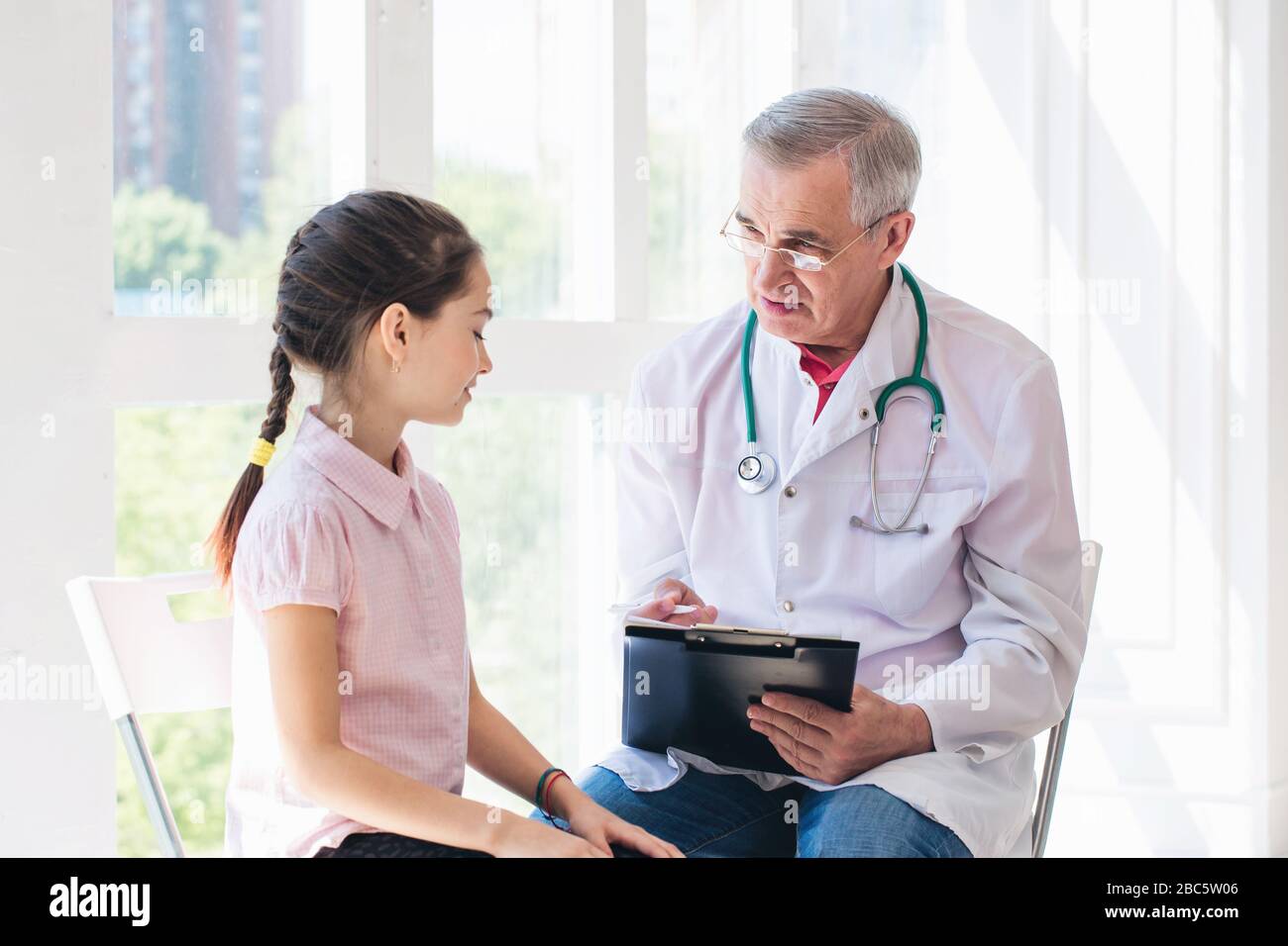 Pediatrician doctor examining child Stock Photo - Alamy